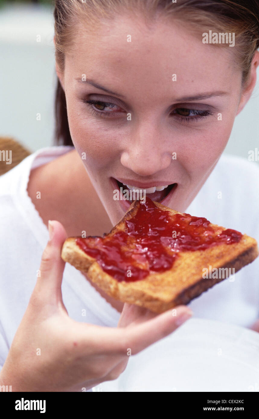Female eating toast with jam Stock Photo - Alamy