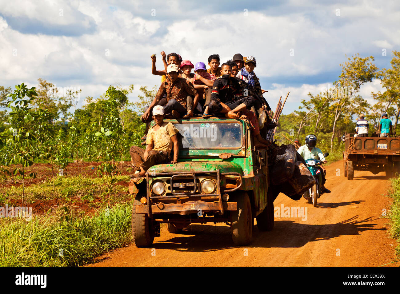 People crowded onto a truck on a dust track in a village near Banlung ...