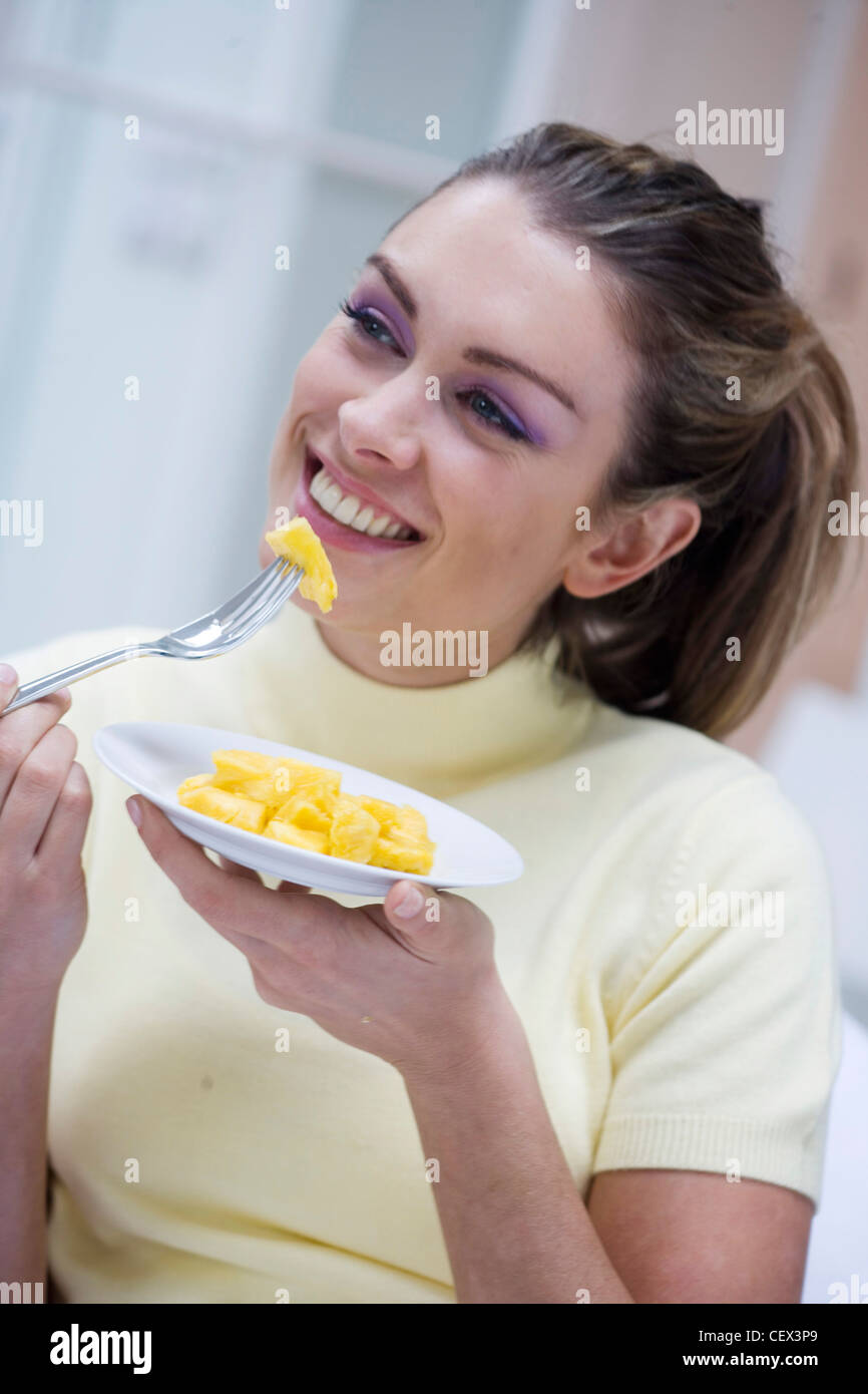 Female eating pineapple Stock Photo - Alamy