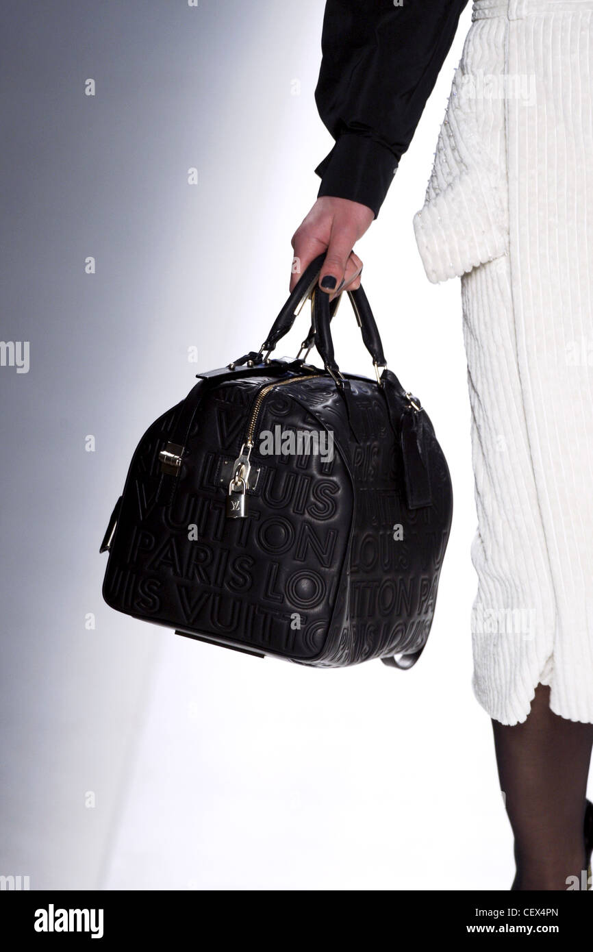 Model holding a black leather oversized handbag with embossed text ...