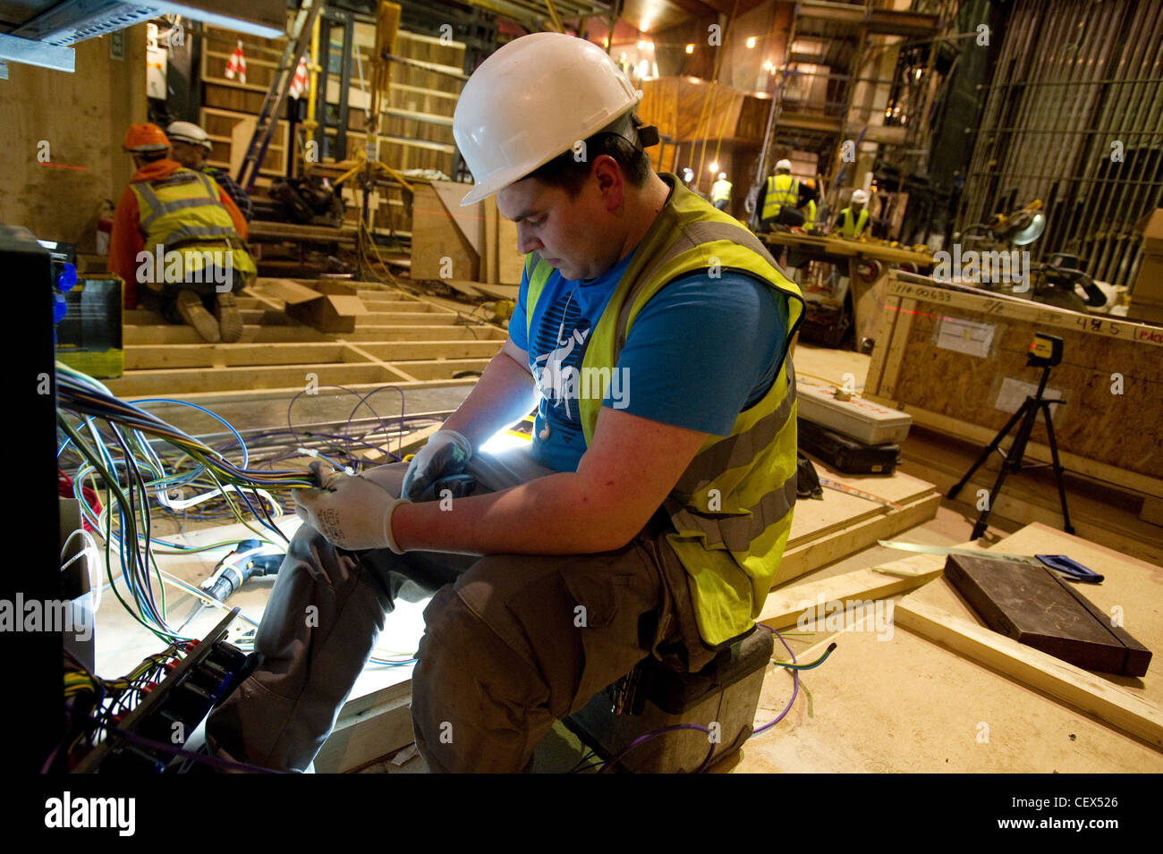Electrician installing cabling, working on a building site Stock Photo ...