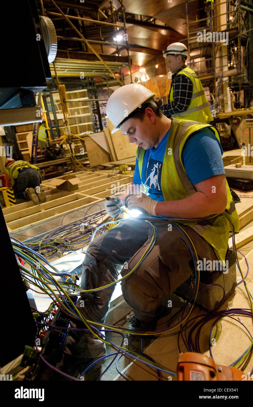 Electrician installing cabling, working on a building site Stock Photo ...