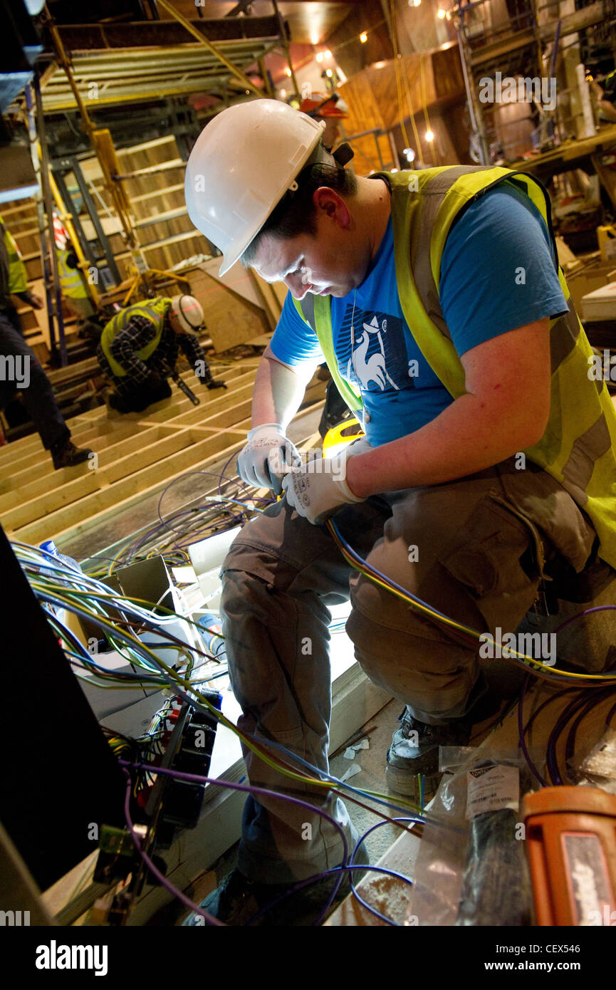 Electrician installing cabling, working on a building site Stock Photo ...