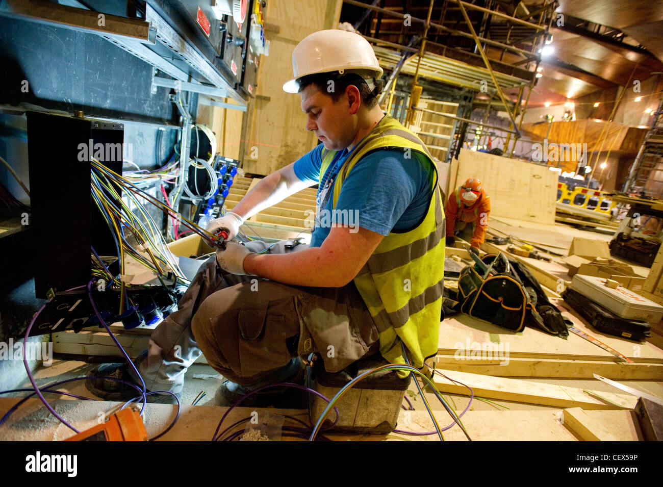 Electrician installing cabling, working on a building site Stock Photo ...