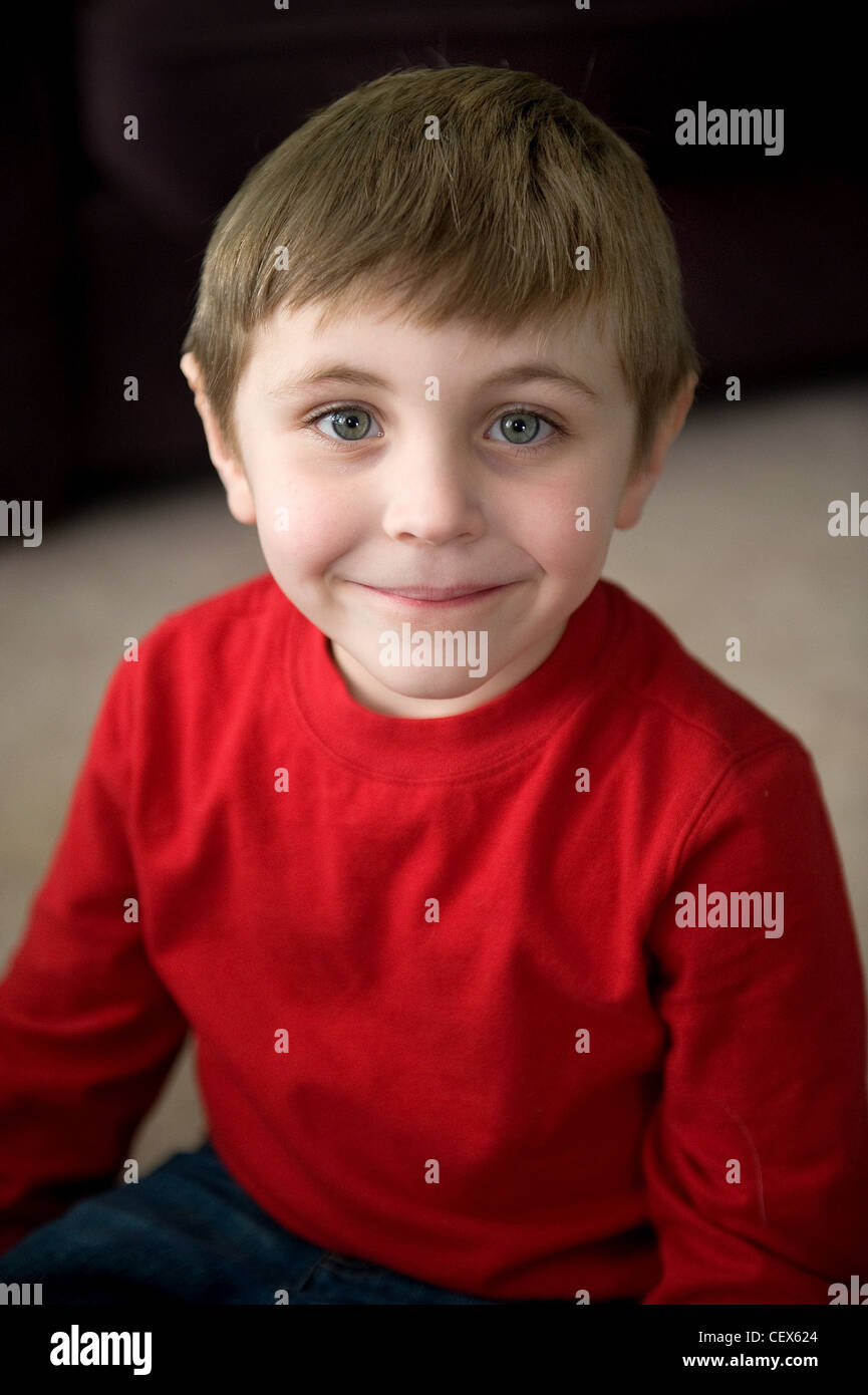 A 4-yr-old caucasian boy smiling looking at camera in long sleeve red ...
