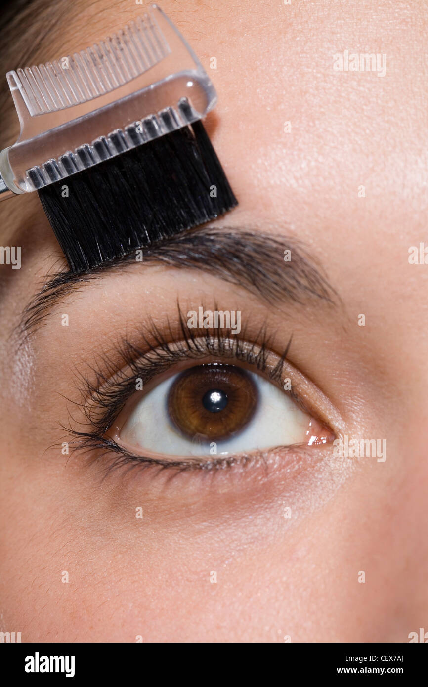 Female brushing her eyebrows Stock Photo - Alamy