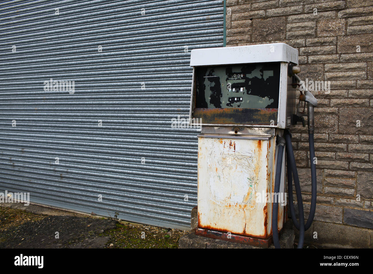 Antique unused broken petrol pump outside a garage door Stock Photo - Alamy