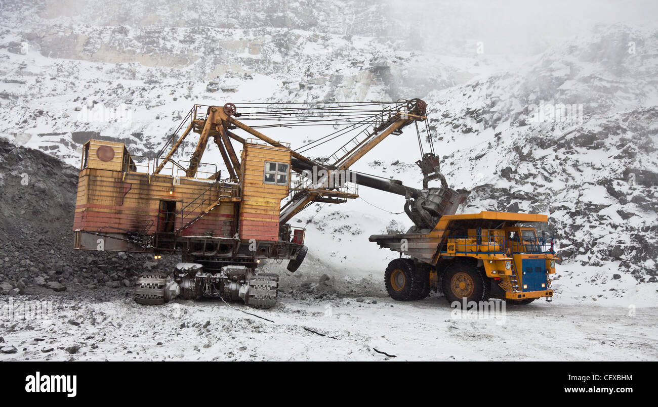 Dump truck loaded with an excavator bucket Stock Photo - Alamy