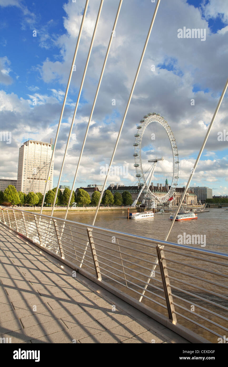 A view of the London Eye framed by the suspension cables on the ...