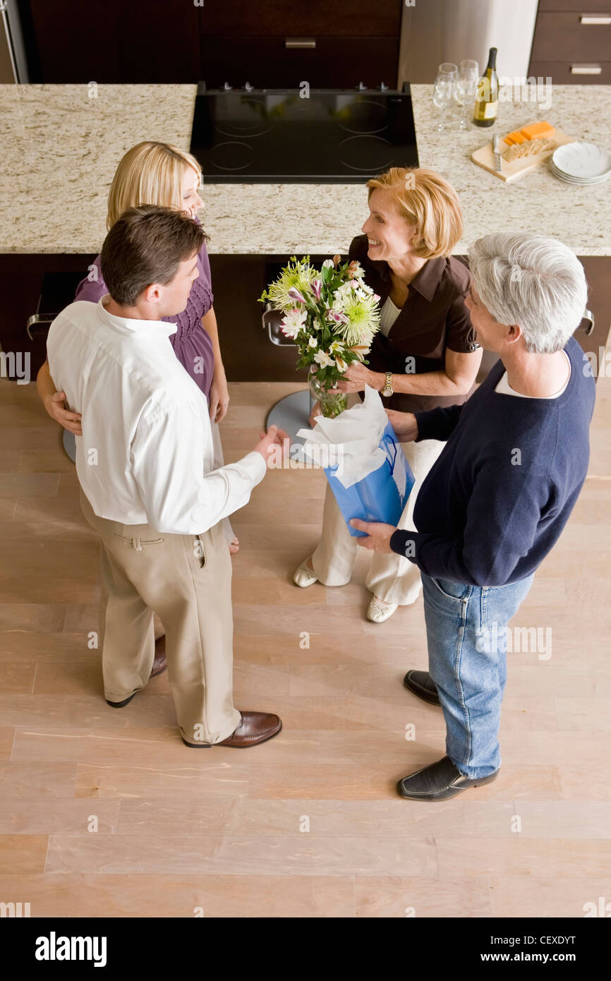 Caucasian couple giving hosts gift and flowers Stock Photo - Alamy
