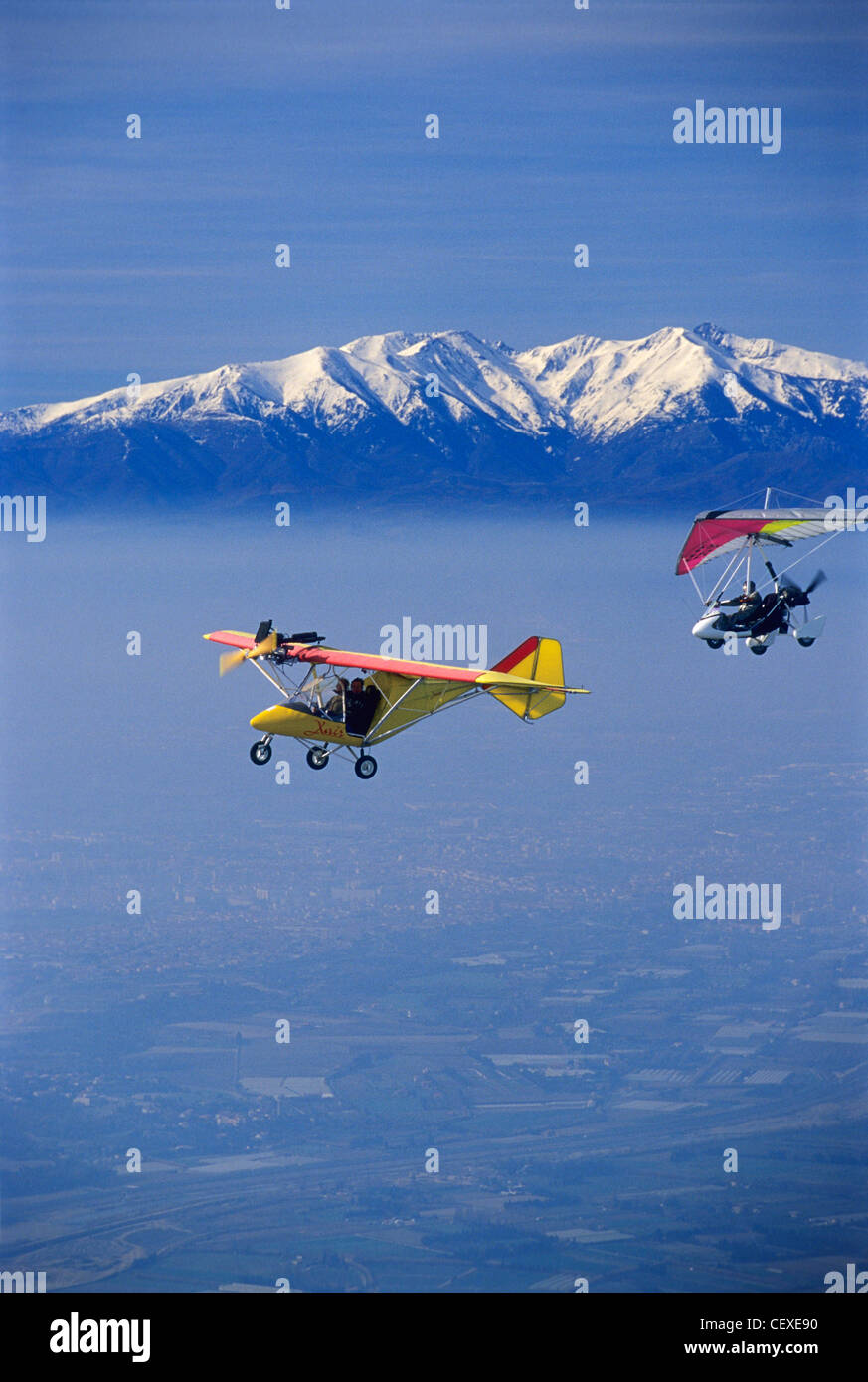 Ultra light planes flying in wintertime. At background Canigou peak ...