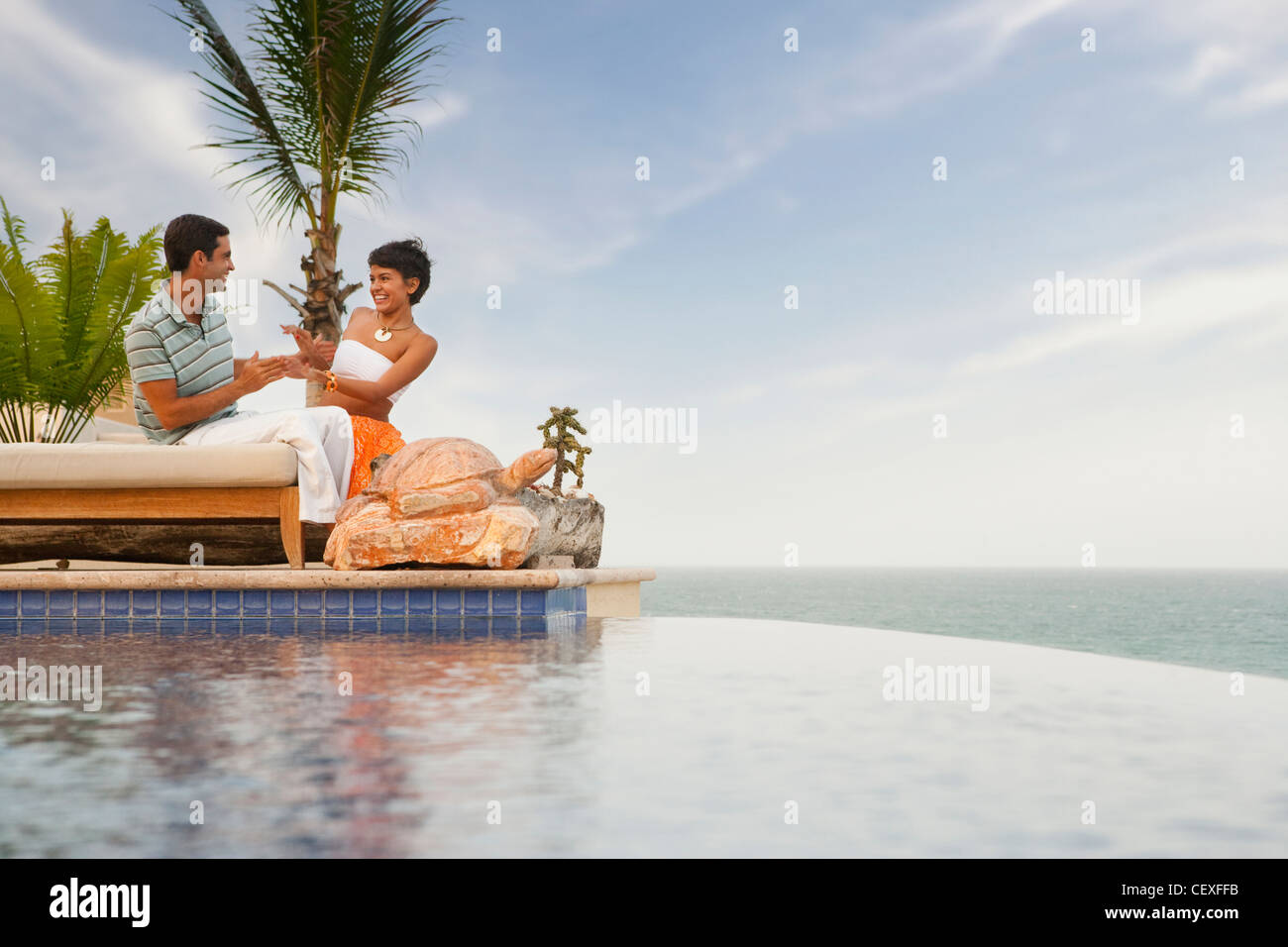 Hispanic couple relaxing near swimming pool Stock Photo - Alamy
