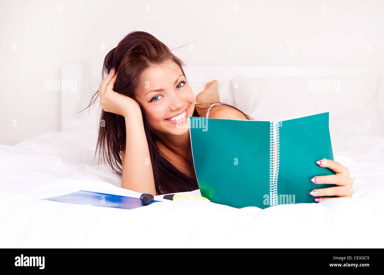 happy student doing homework in bed at home Stock Photo - Alamy