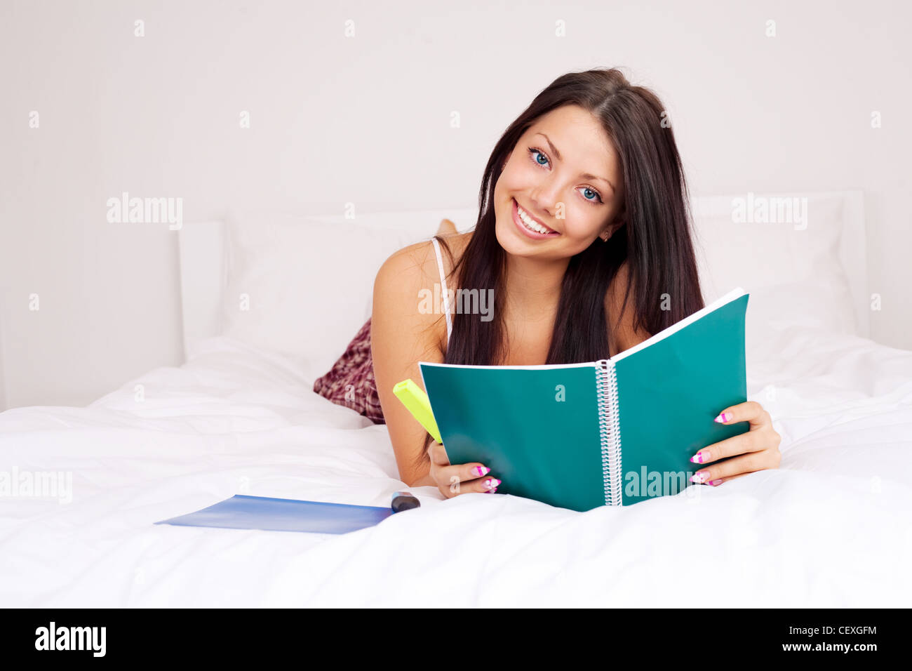 happy student doing homework in bed at home Stock Photo - Alamy