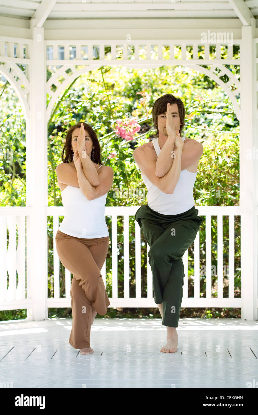 Couple doing yoga in gazebo Stock Photo - Alamy