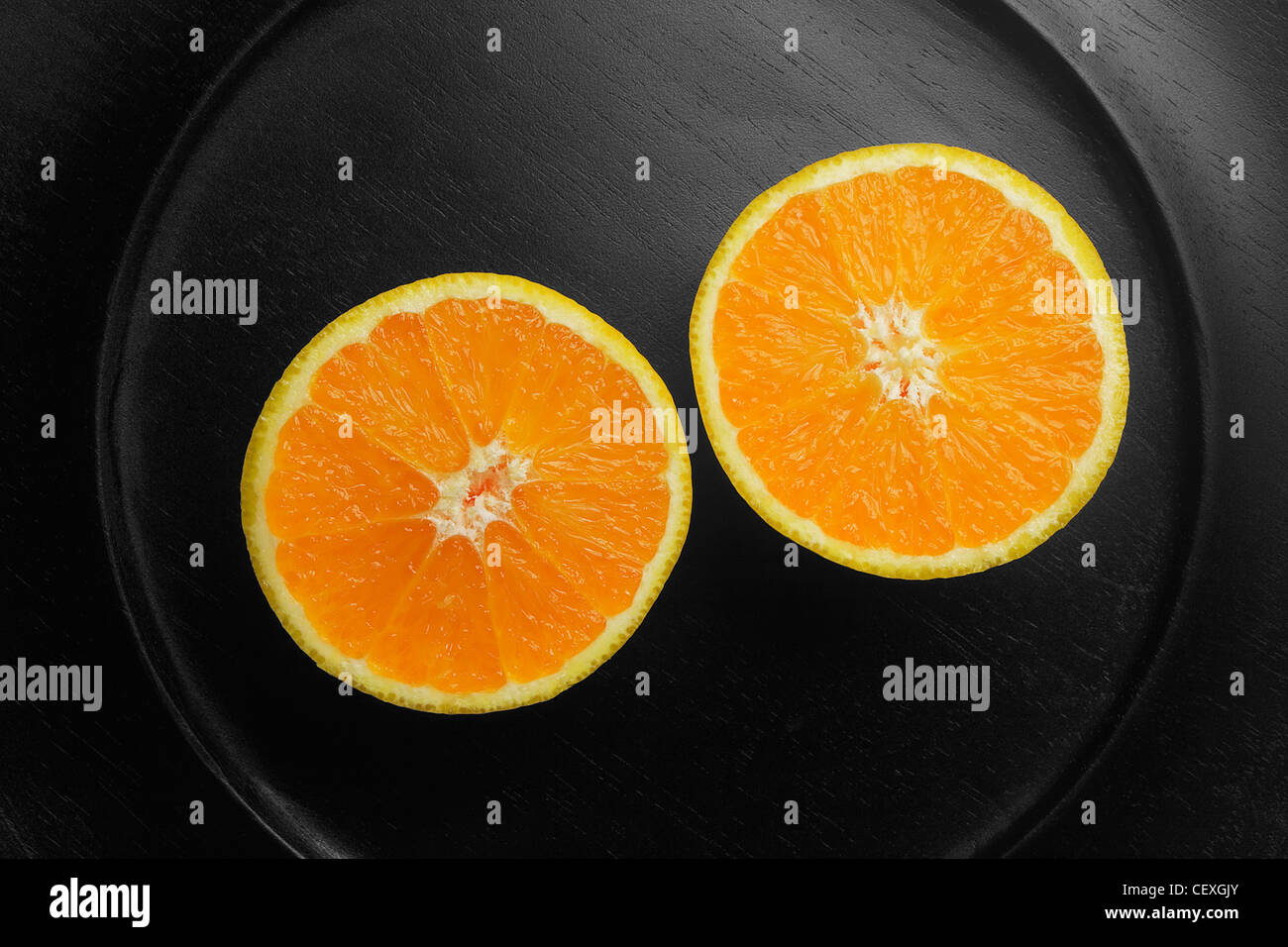 Orange Halves on black wooden plate Stock Photo - Alamy