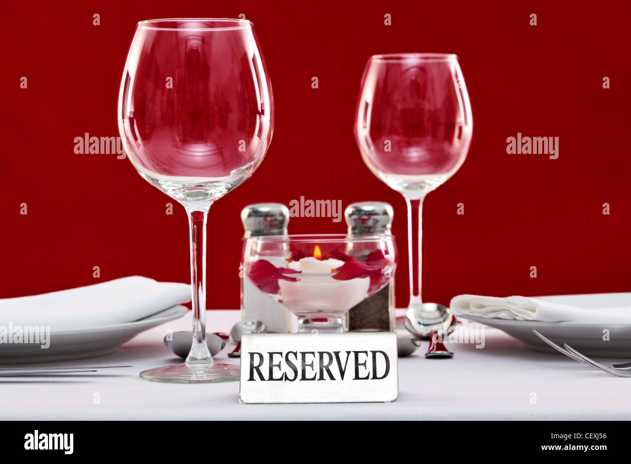 Photo of a Reserved sign on a restaurant table with red background ...
