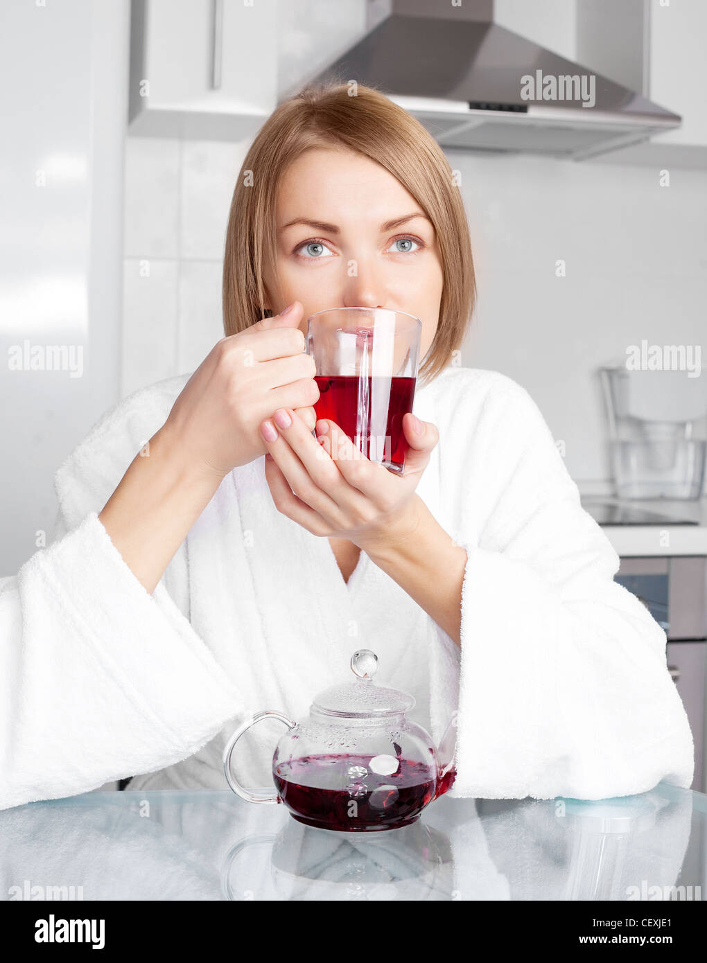 beautiful young woman drinking tea in the kitchen at home Stock Photo ...