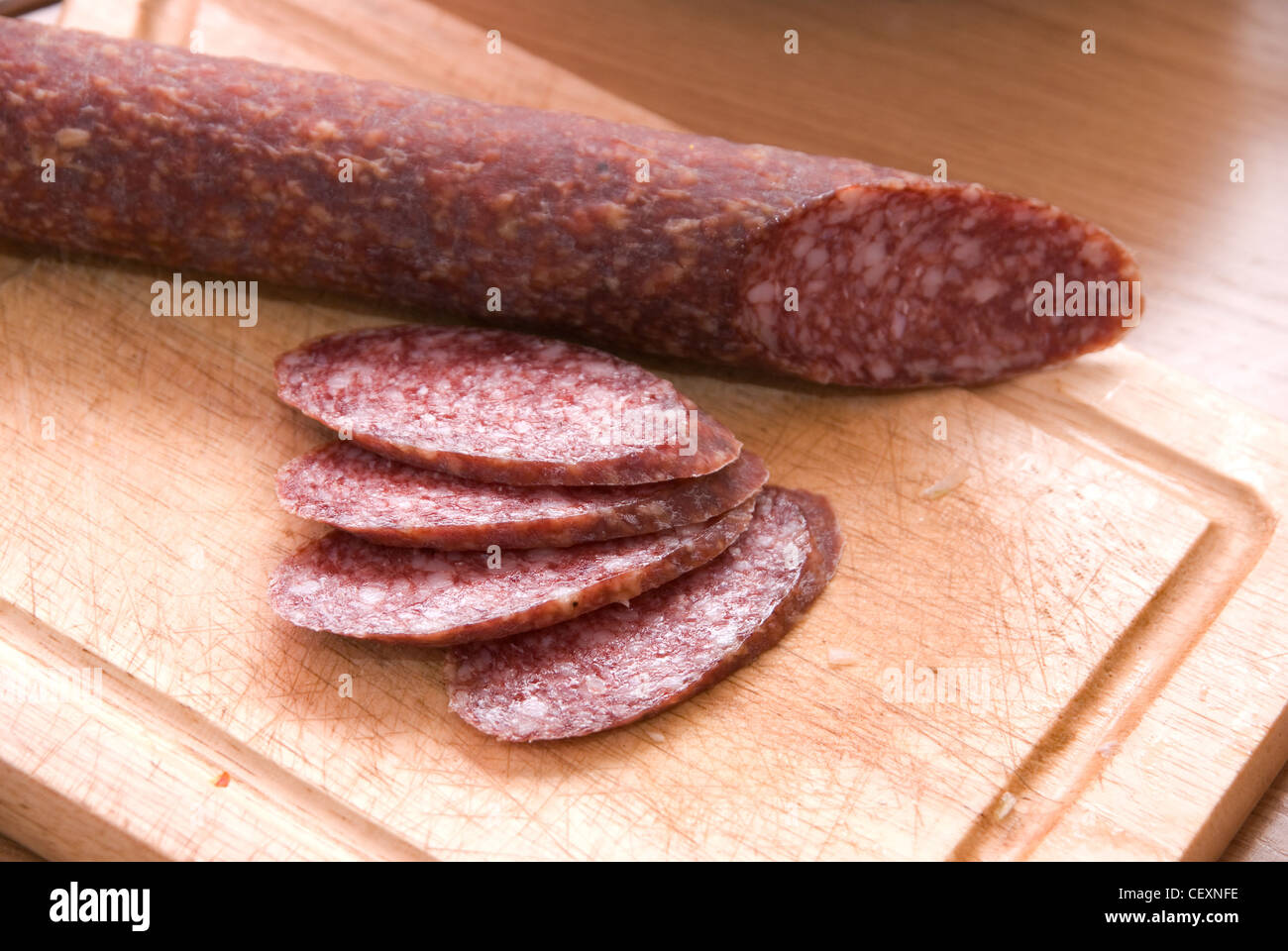 An salami with sliced pieces at table Stock Photo - Alamy