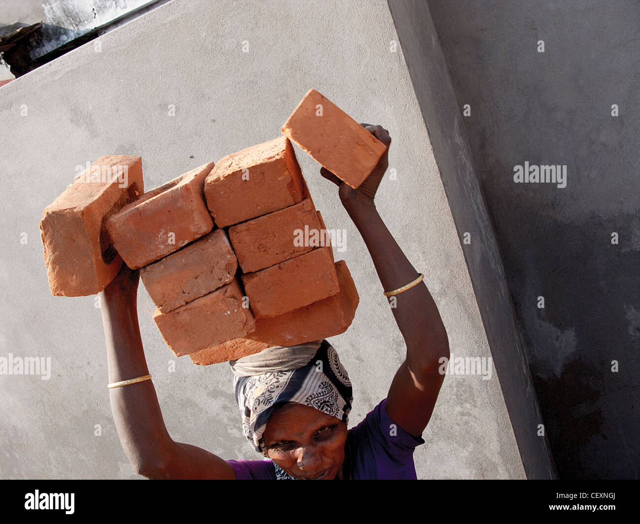 Carrying bricks on their head hi-res stock photography and images - Alamy