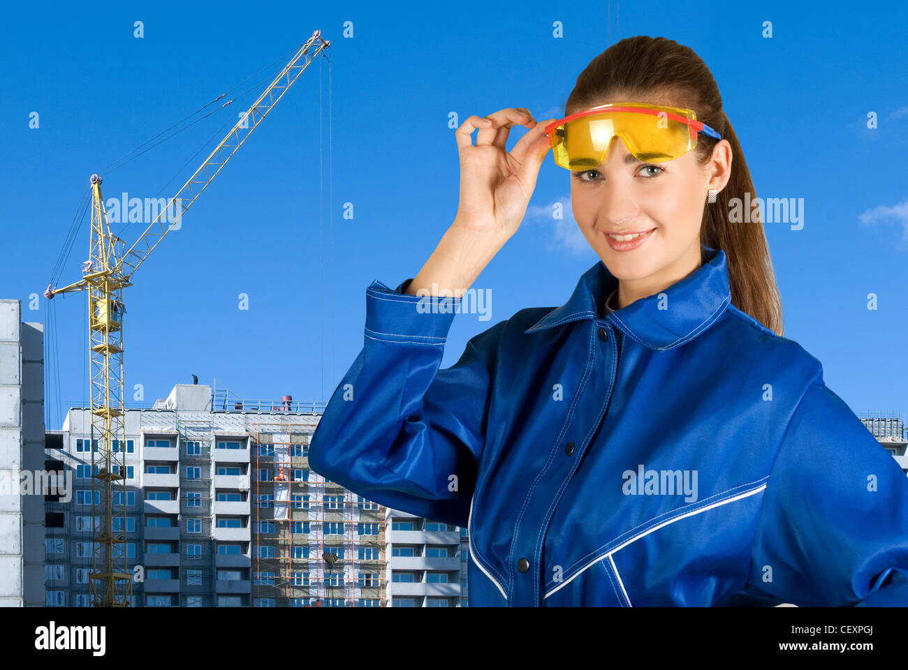 Builder pretty girl at safety glasses on a building background Stock ...