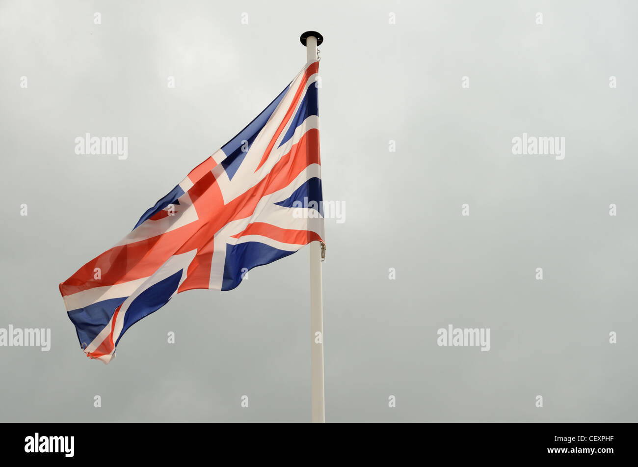 A union jack flag flying in a clear blue sky showing movement from the ...
