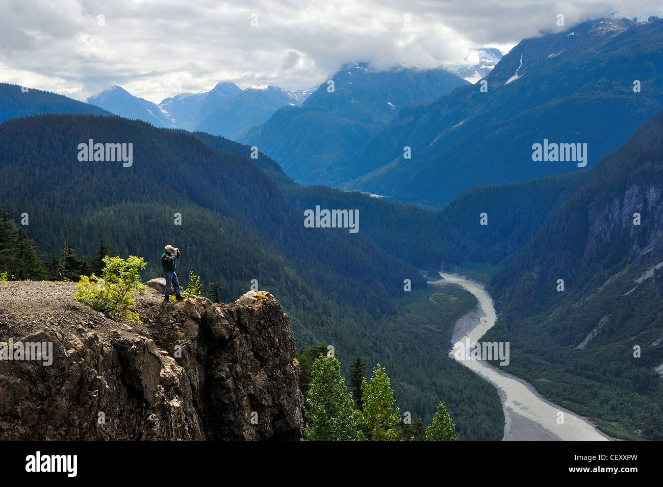 A lone hiker stops on a mountain ridge to view the Salmon river valley ...
