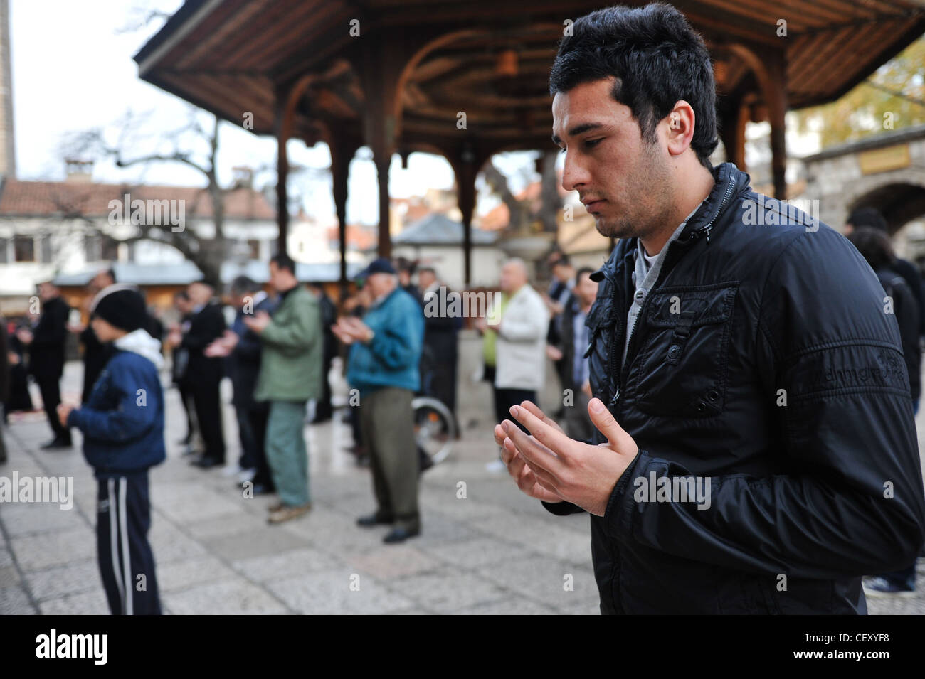 A young Bosnian Muslim man prays in front Husrev Bey's mosque in ...