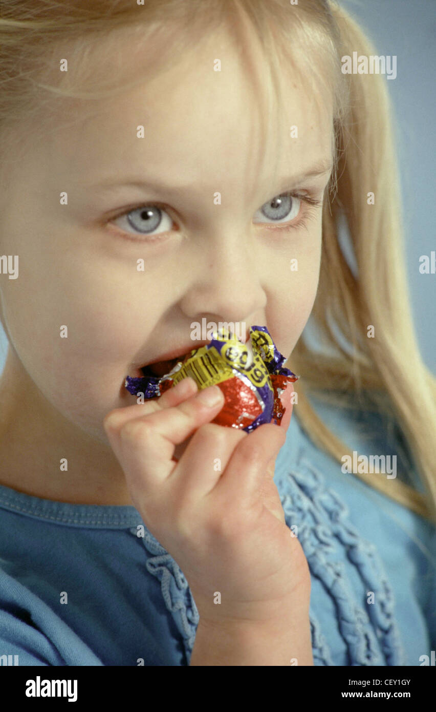 Female child eating cream egg Stock Photo - Alamy