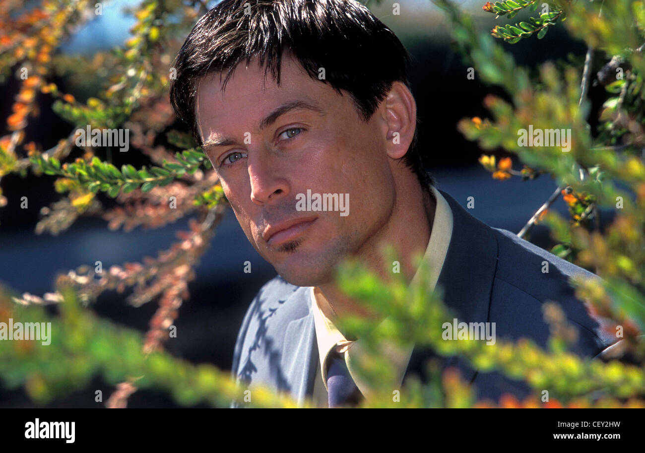Male short brown hair very small tuft of facial hair wearing grey suit ...