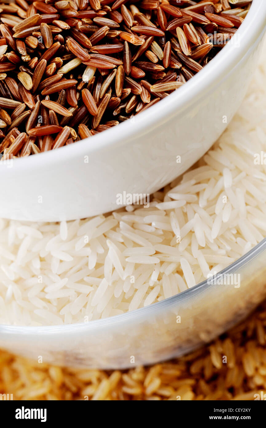 A close up of three stacked bowls of red rice, basmati rice and brown ...