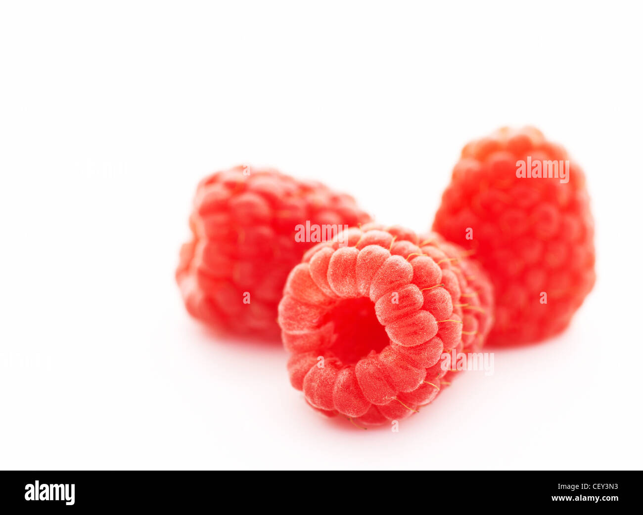 Three red ripe raspberries on white background Stock Photo - Alamy
