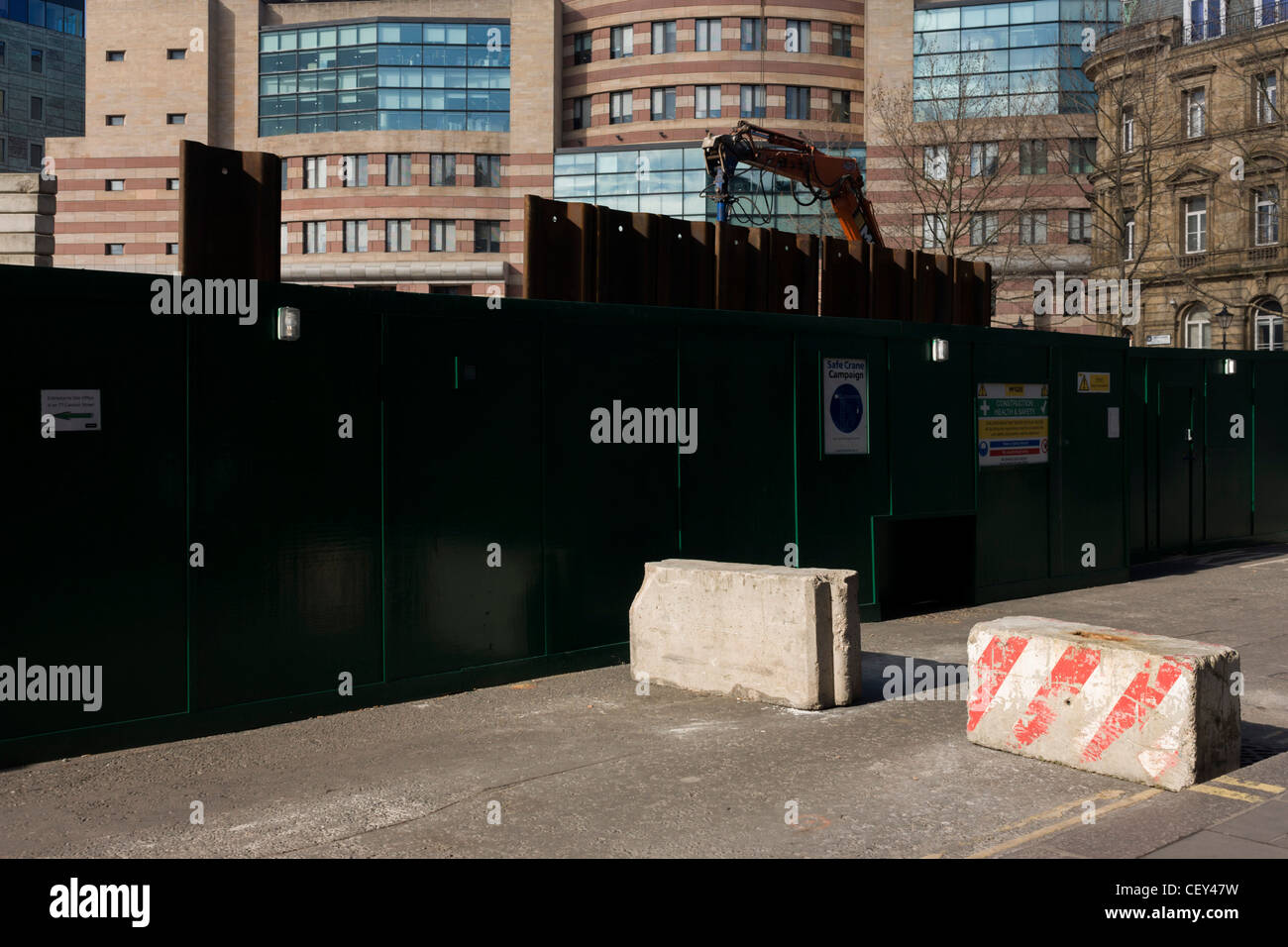 Construction concrete barriers and hoarding and modern city background ...