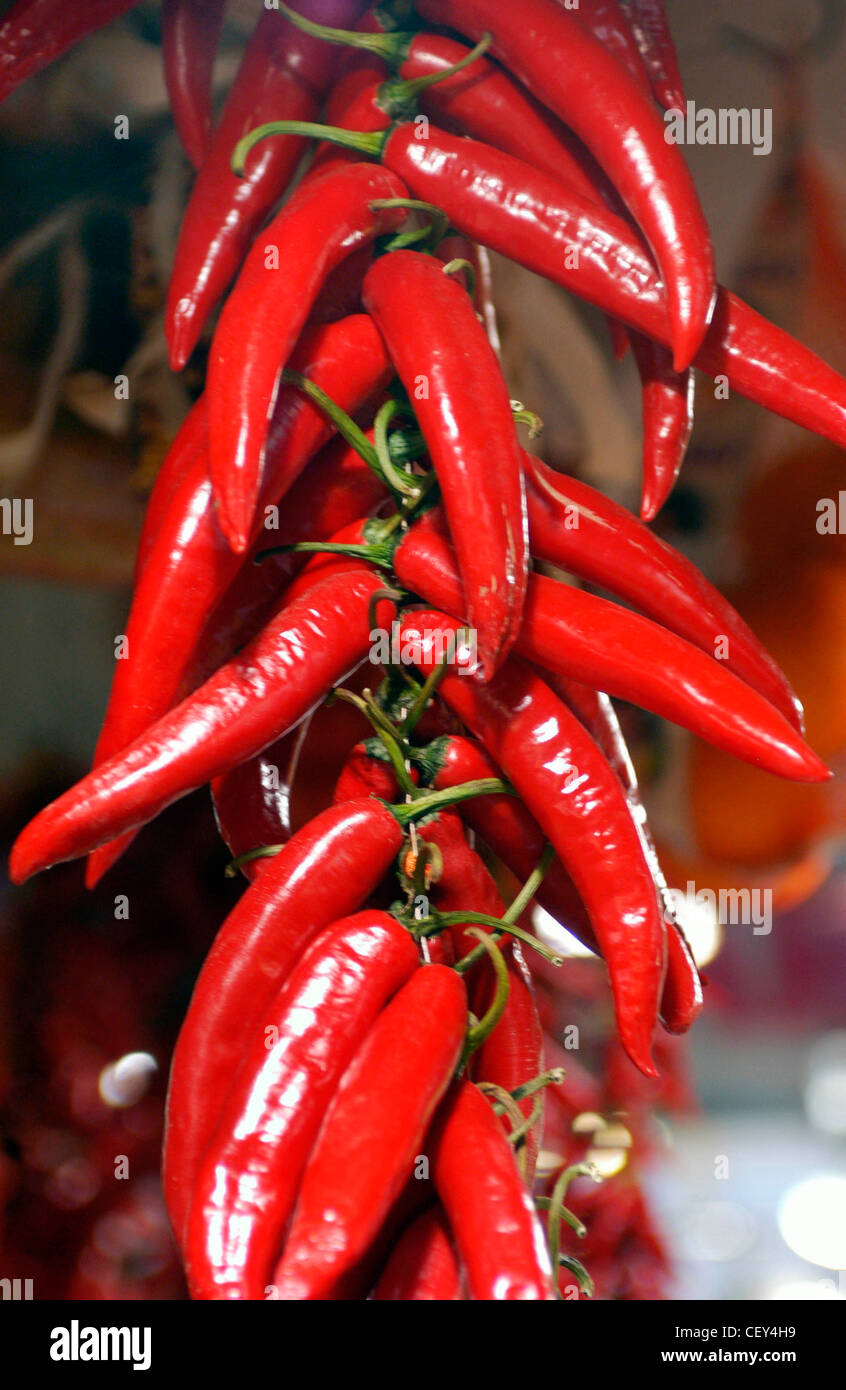 String of red chilli peppers hanging on market stall Stock Photo - Alamy