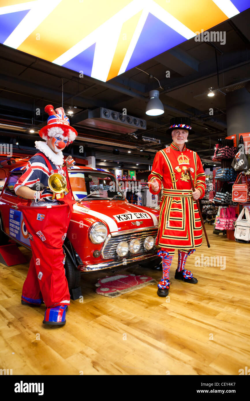 Two people in British themed costumes pose with an old mini cooper ...