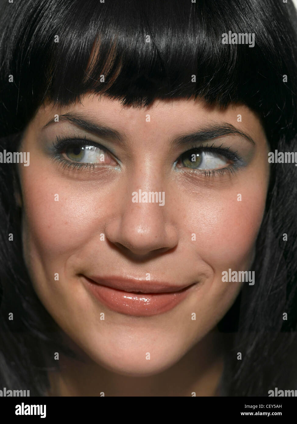 Female with dark brunette hair and fringe with blue eyeshadow, looking ...