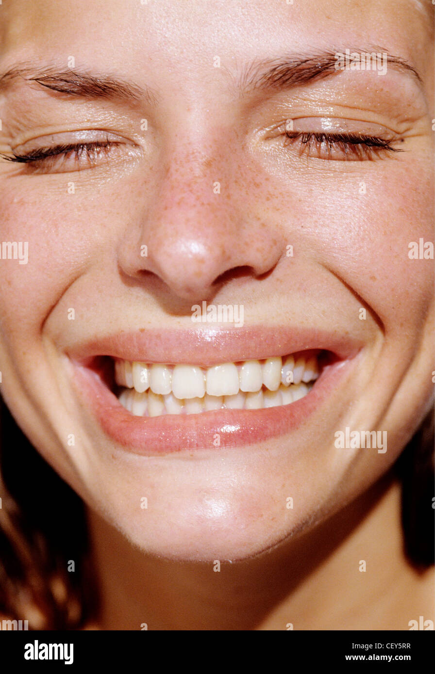 Close up face of Female smiling with eyes shut Stock Photo - Alamy