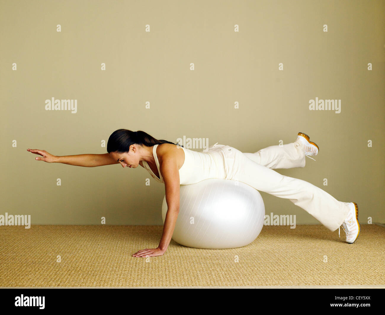 Female wearing white vest and long white training pants performing an ...