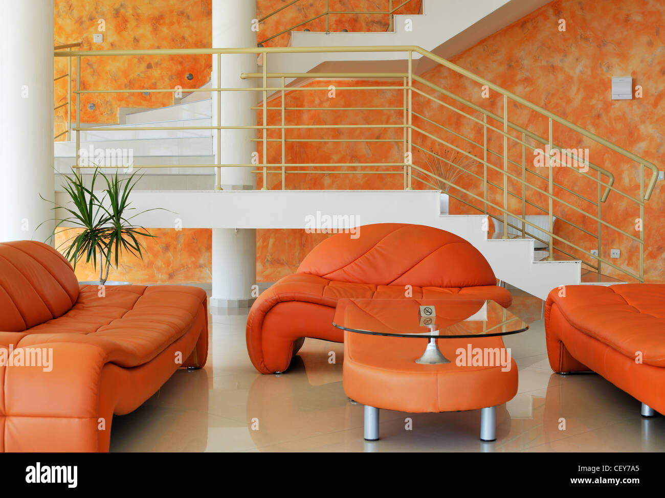 Interior of a hotel reception with colorful orange furniture and stairs ...