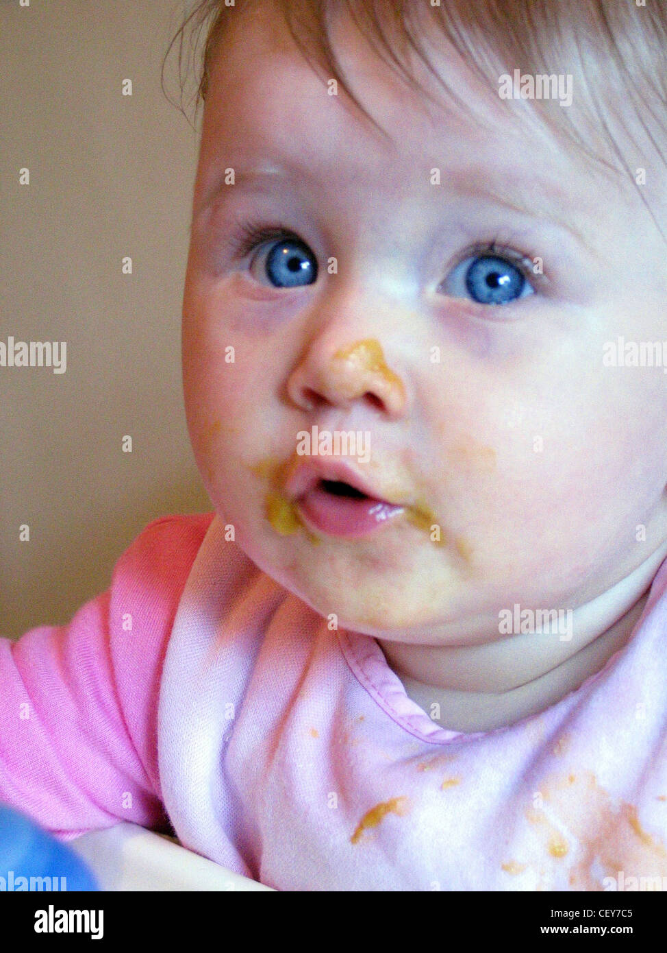 Baby with food on its face wearing a dirty bib Stock Photo - Alamy
