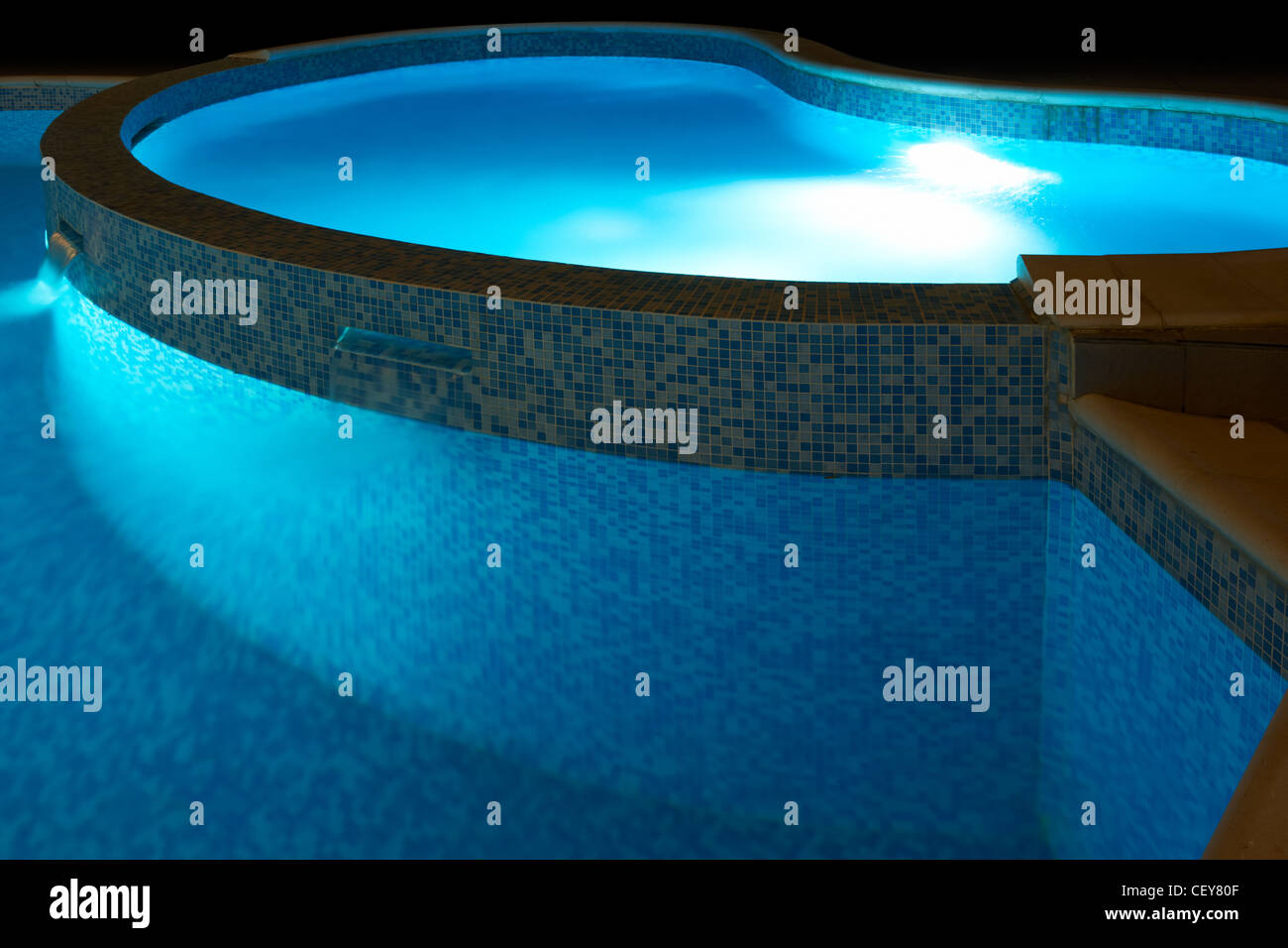 Small swimming pool with blue water and lights at night Stock Photo - Alamy