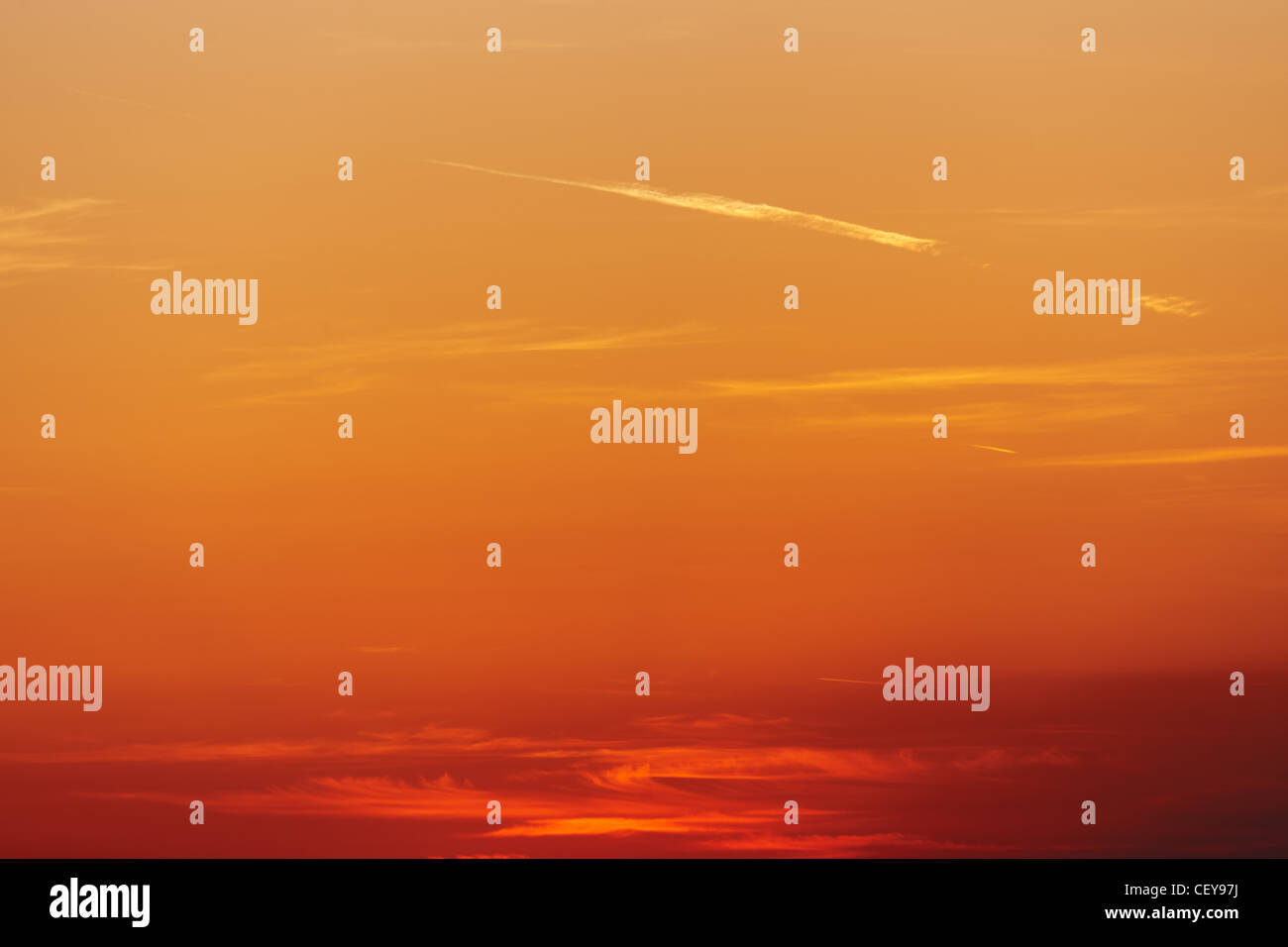 Colorful red sunset sky with plane traces Stock Photo - Alamy