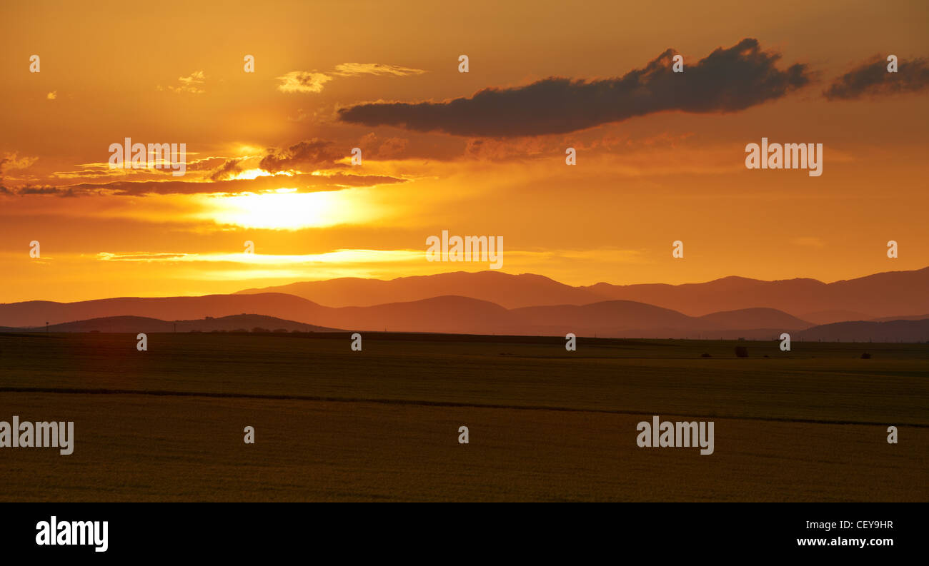 Landscape scenery with sunset over field and mountains Stock Photo - Alamy
