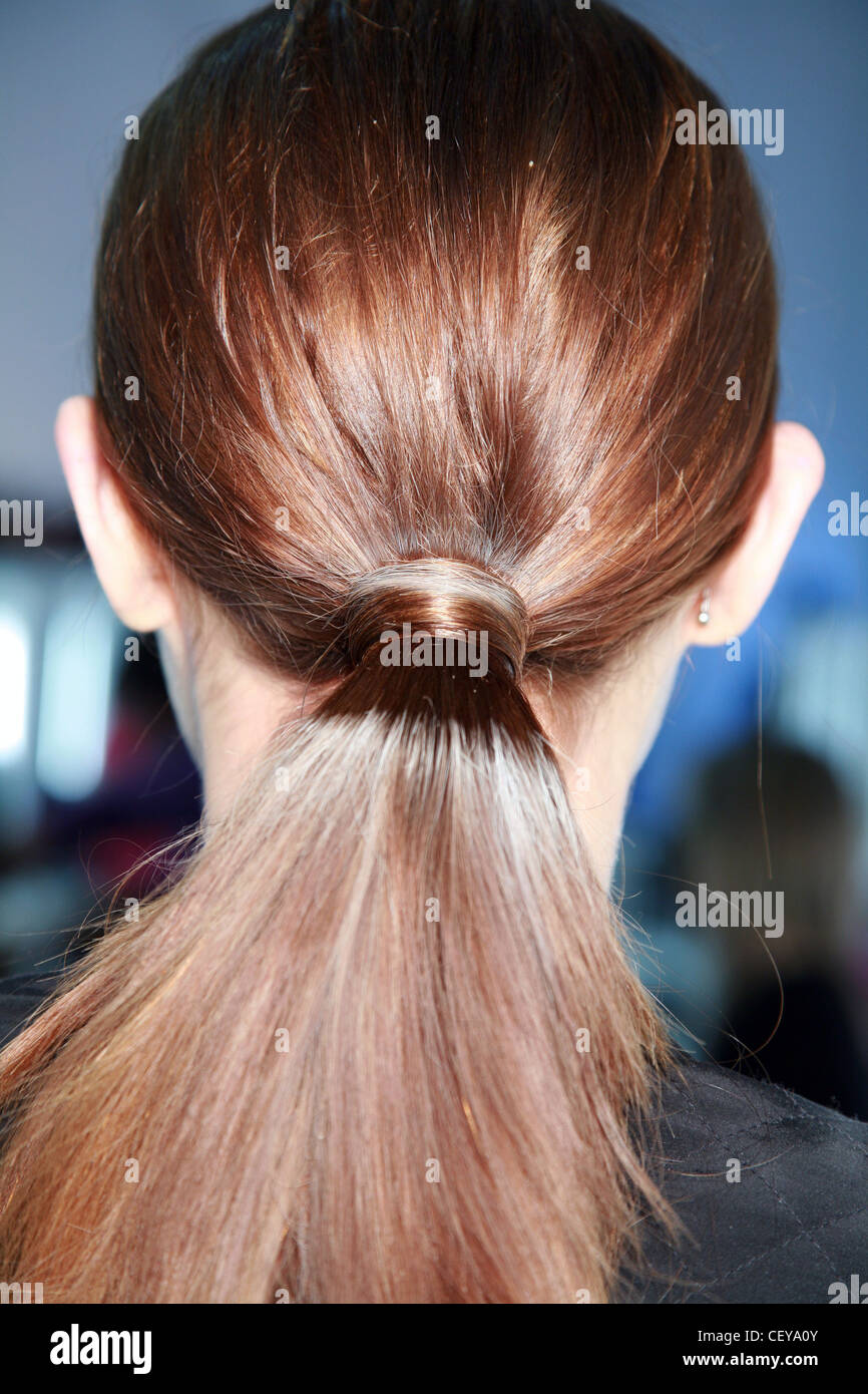View from behind of model with straight red hair in ponytail partly ...