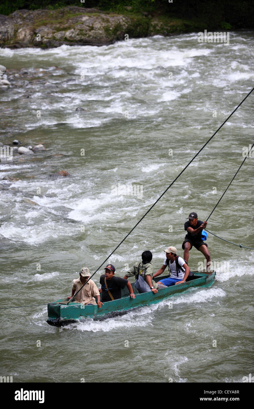 Crossing the Bahorok River by rope stabilized canoe. Bukit Lawang ...