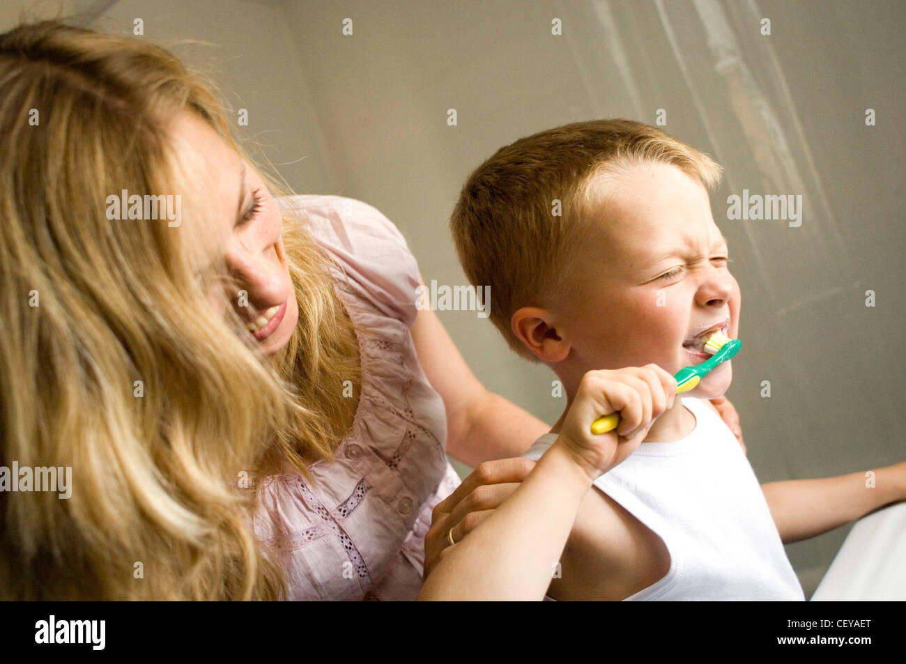 Female with long blonde hair, pale pink top, forcing male child, blonde ...