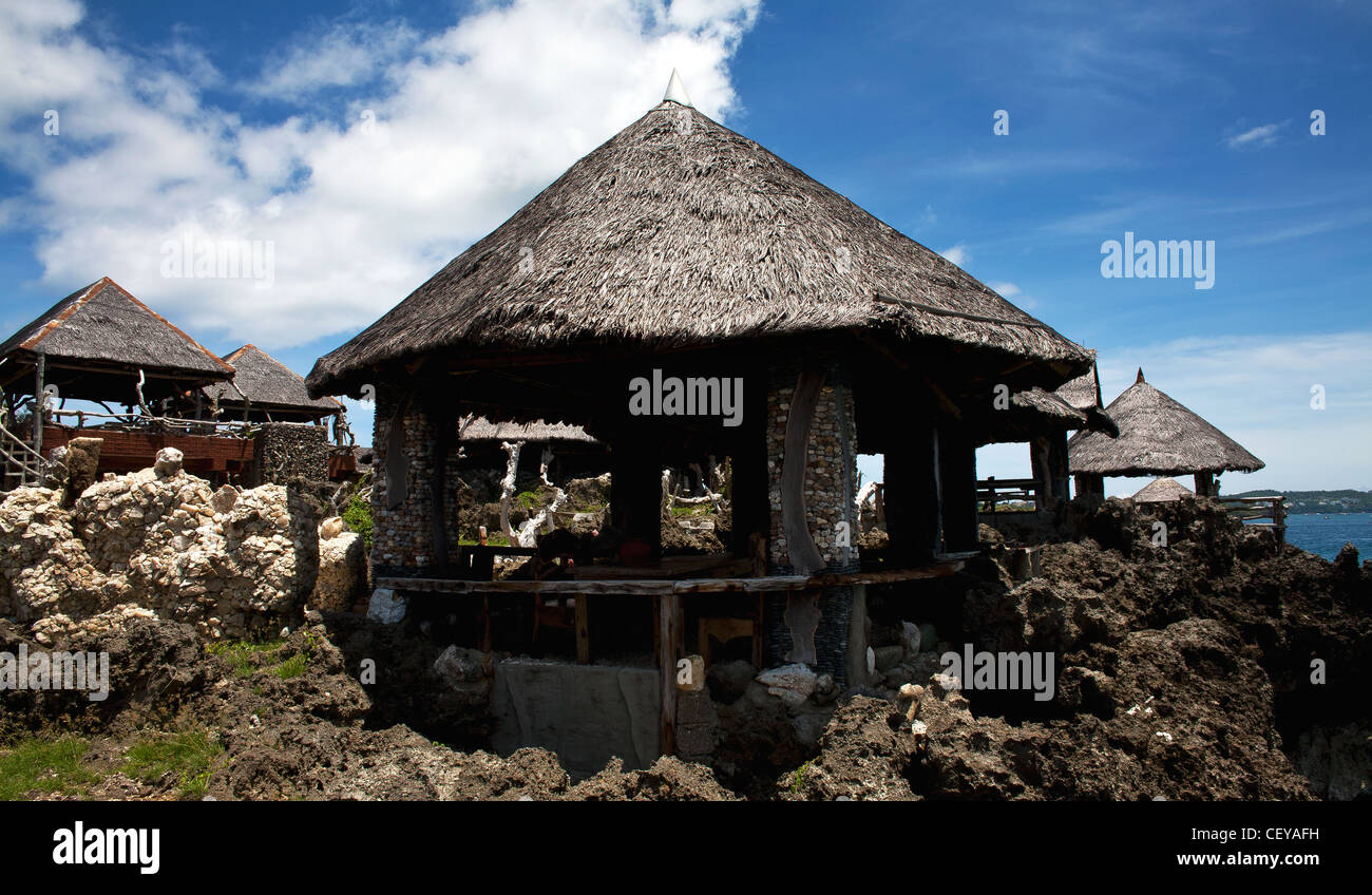 A gazebo sits on the water under the blue sky on Crystal Cave Island ...