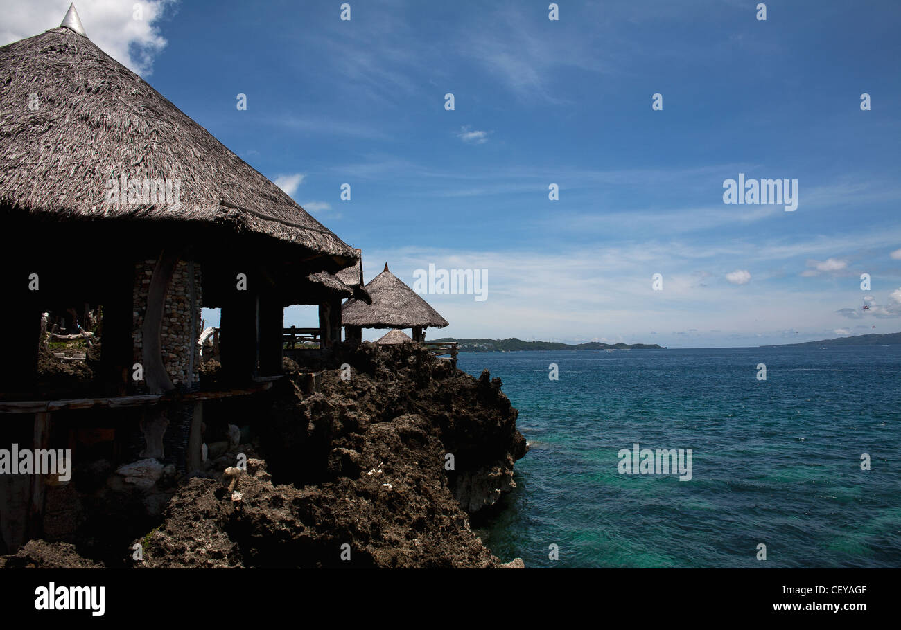 A gazebo sits on the water under the blue sky on Crystal Cave Island ...