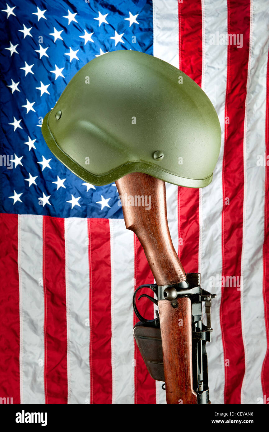 An old WWII Enfield rifle with helmet against an American flag, a ...