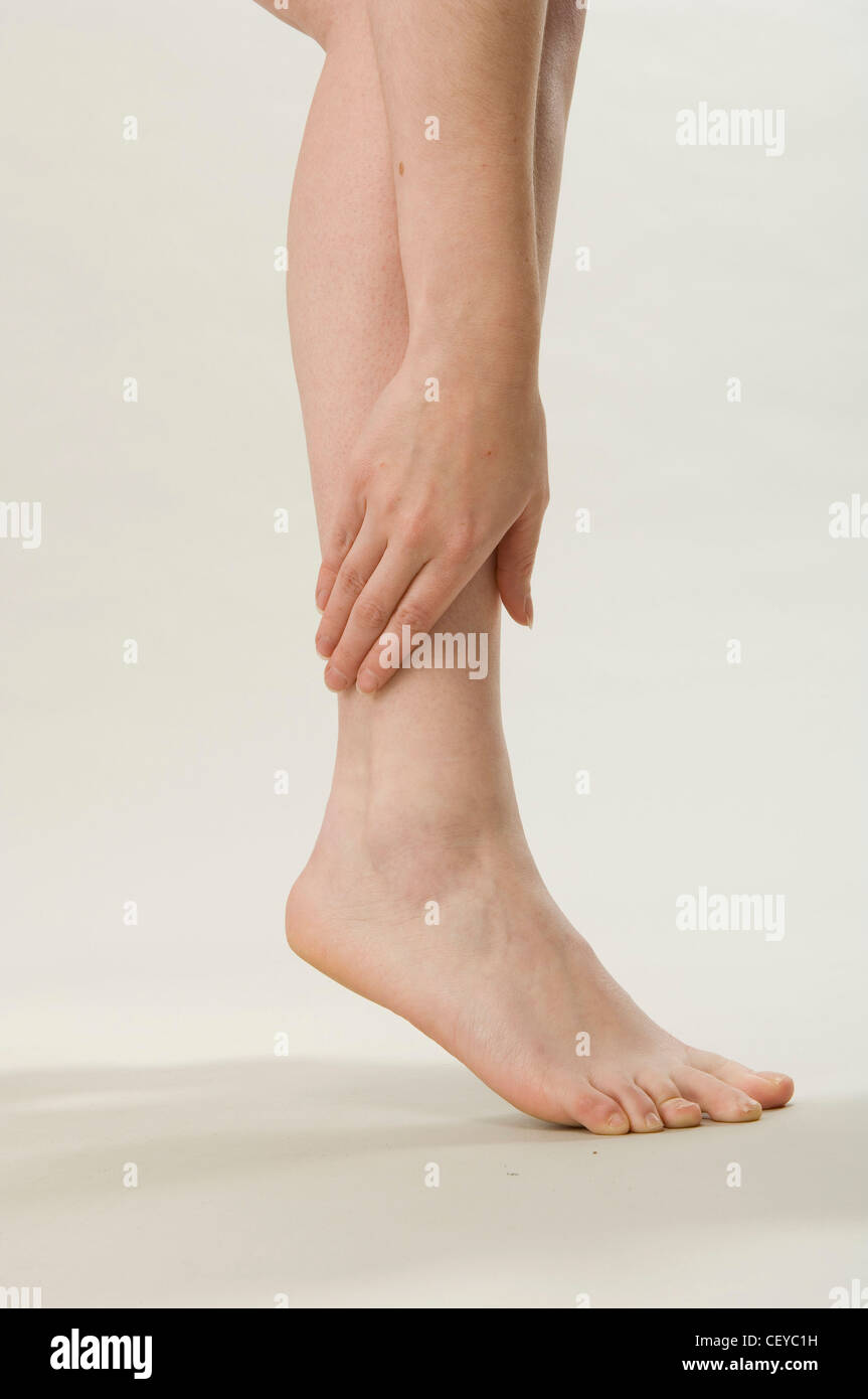 Female hand touching leg Stock Photo - Alamy